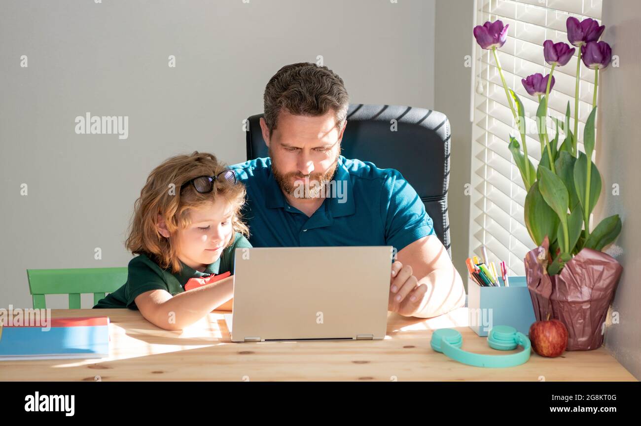 attentive father and child son at school working online on laptop ...