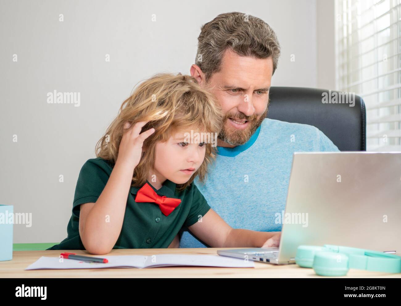 happy attentive father and child son at school working online on laptop ...