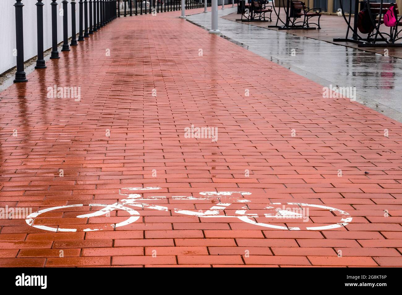 Bicycle markings. Red brick bike path. Wet bicycle path. The sidewalk ...