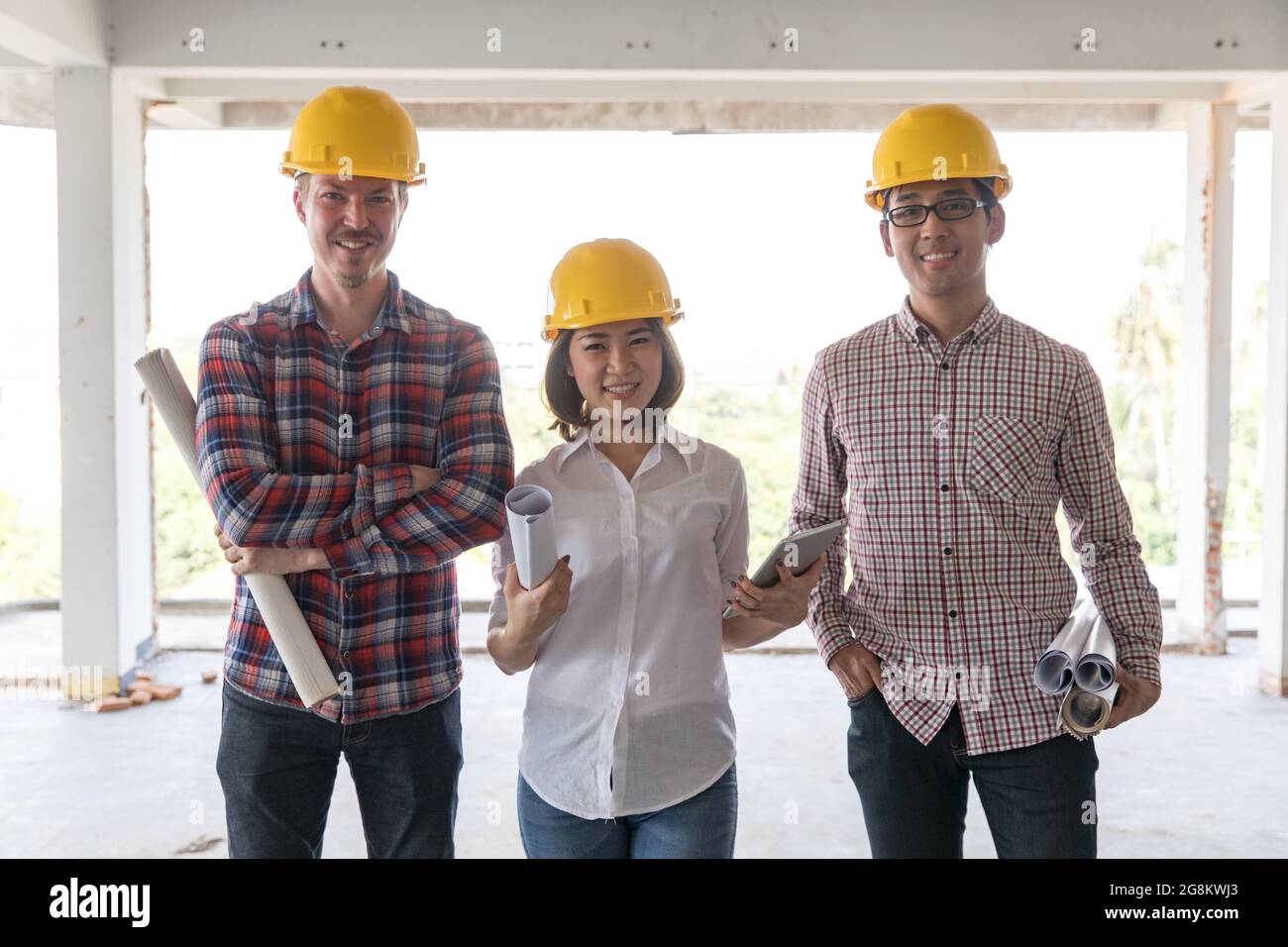 Diversity team of engineer, one woman and two men, standing together ...