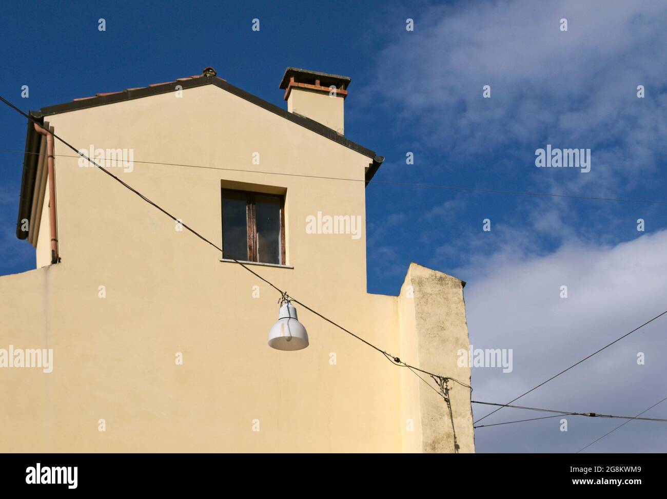 house facade with window and street lamp hanging on wire Stock Photo ...