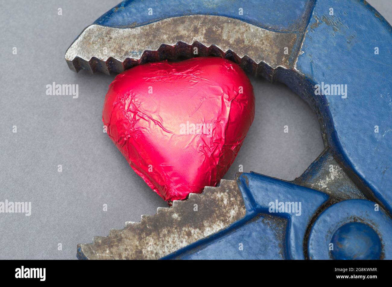 heart shape held in jaws of wrench Stock Photo - Alamy