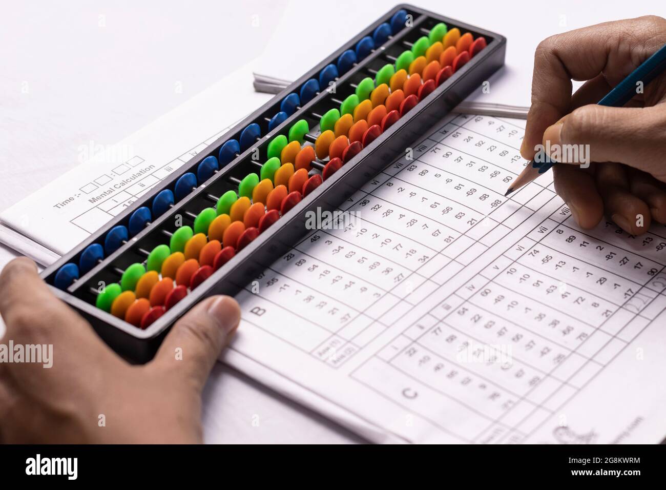 selective focus on human hand doing abacus calculations on white ...