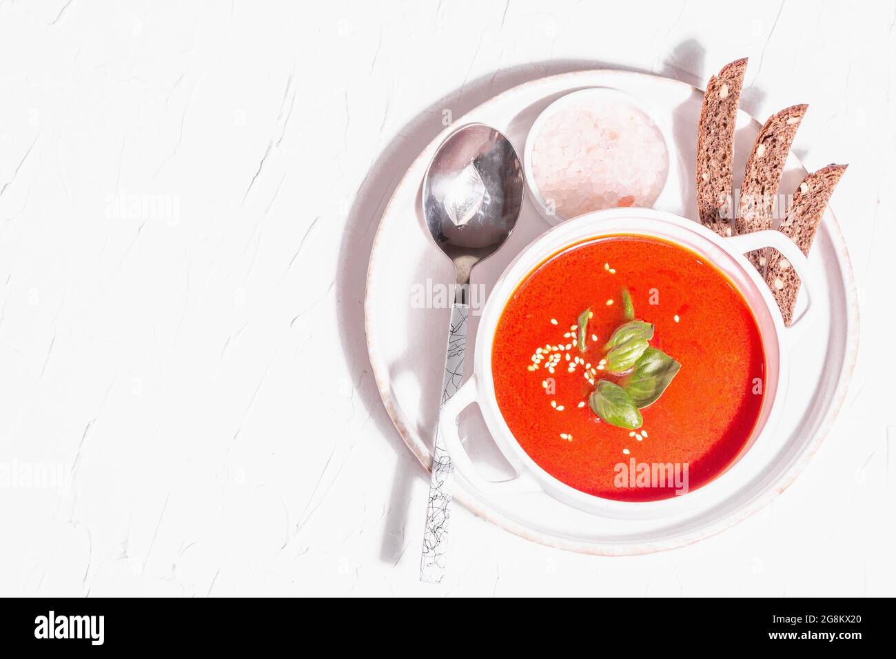 Red puree soup with tomato, greens, and bread. Trendy hard light, dark ...