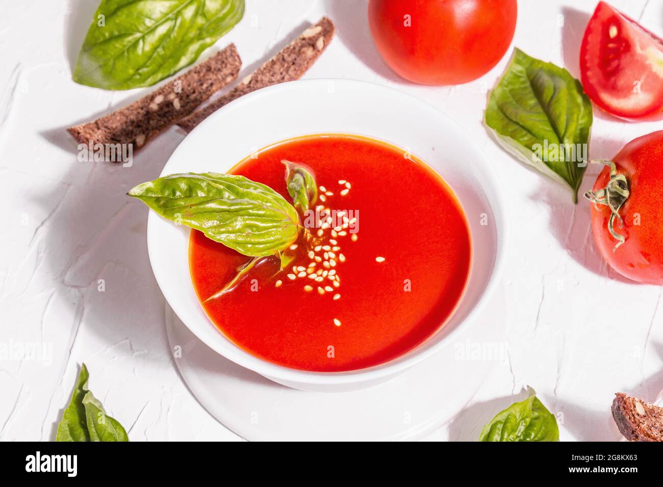 Bowls with homemade tomato soup. Ripe vegetables, fresh basil leaves ...