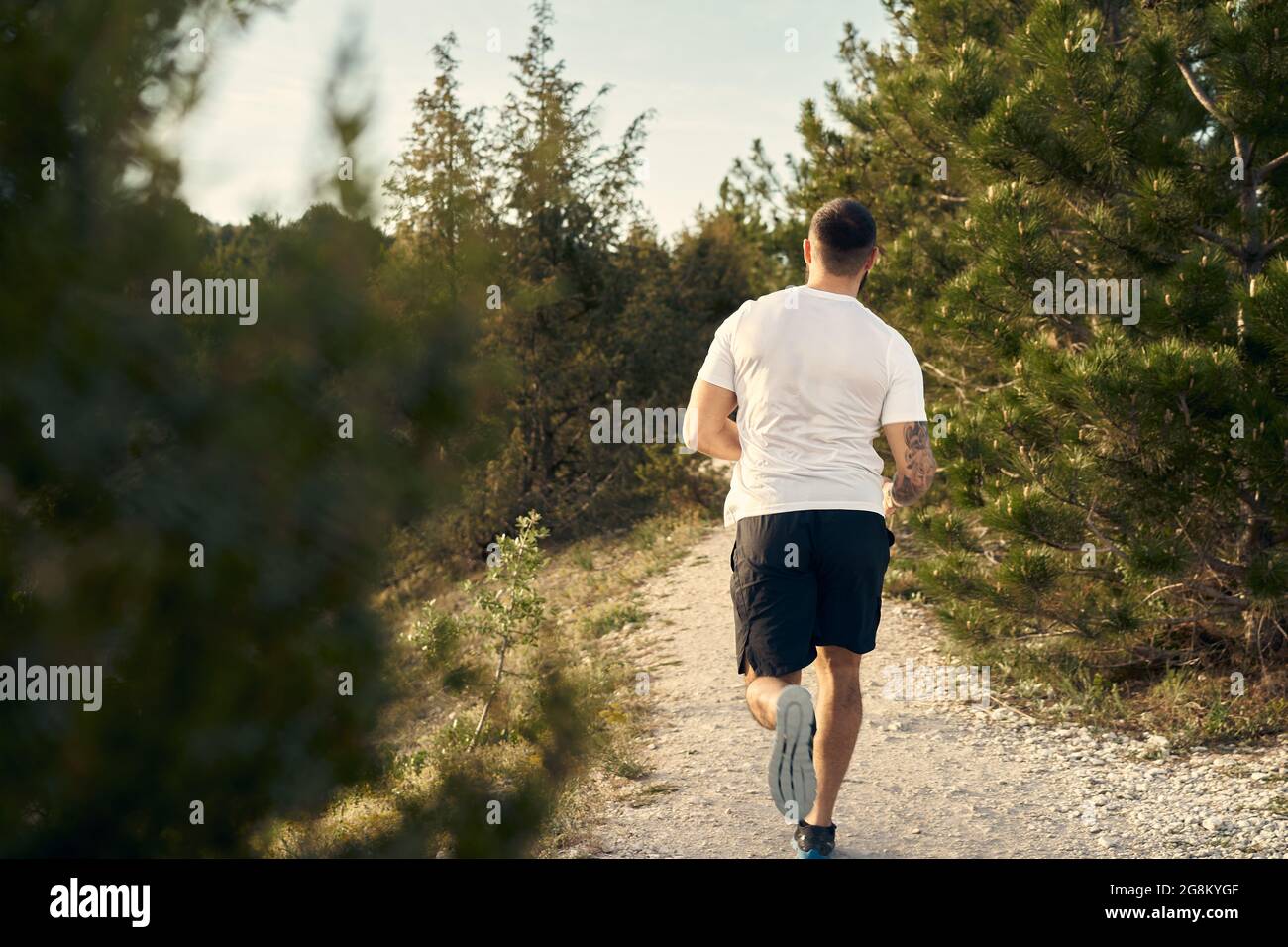 Young muscular male athlete running up the hill Stock Photo - Alamy