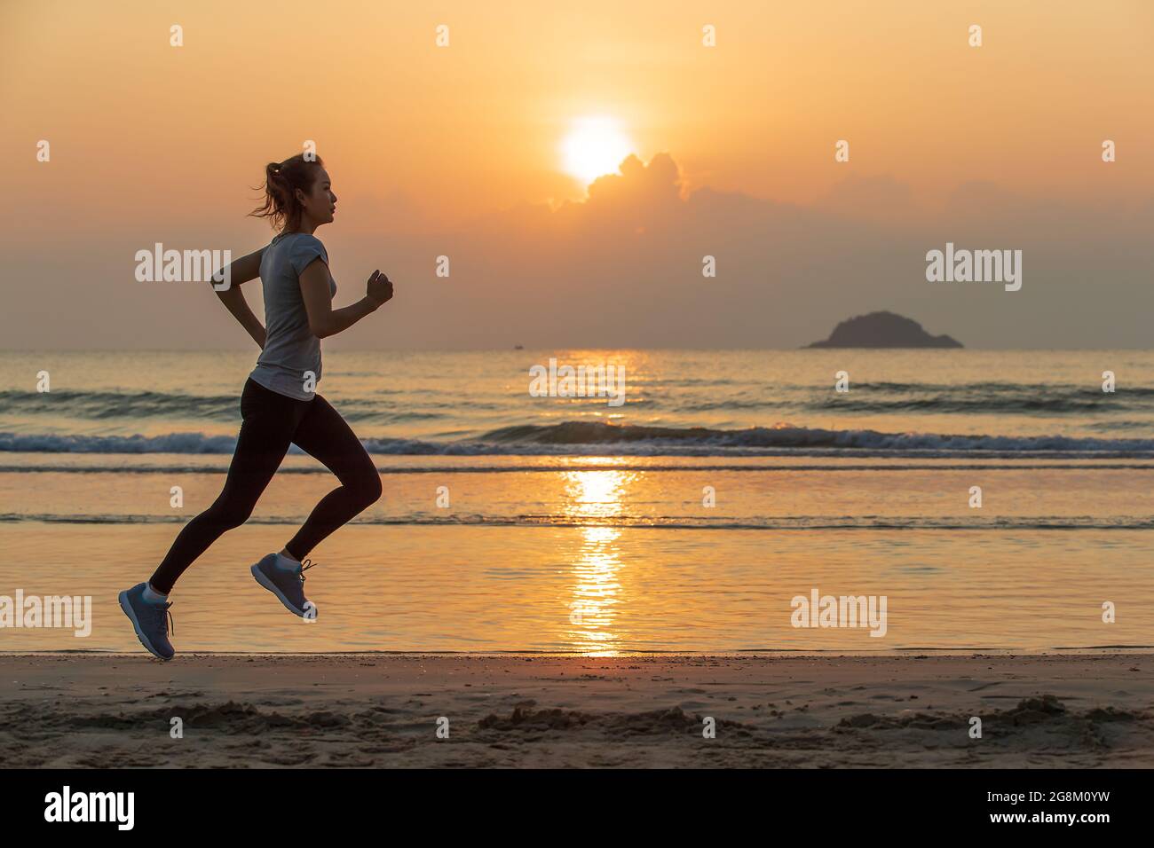 Woman running on beach at sunrise hi-res stock photography and images ...