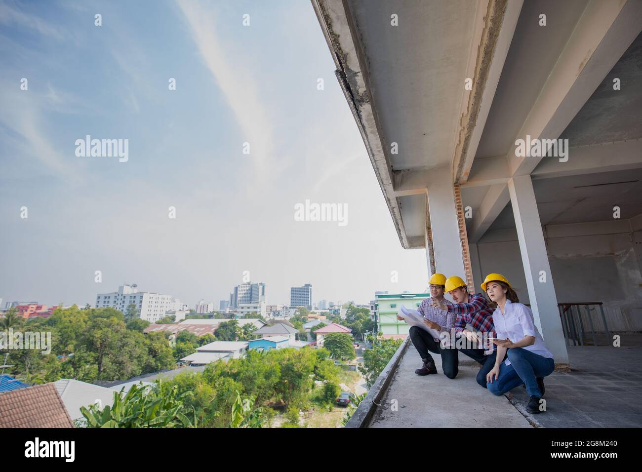 Three of diverse group of engineer team working together in costruction ...
