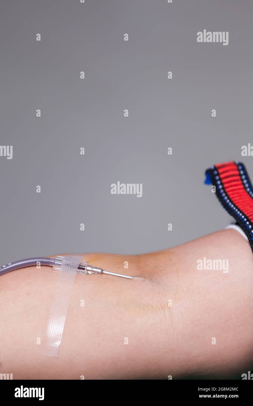 Arm of blood donator with needle and rubber tube in blood donation ...