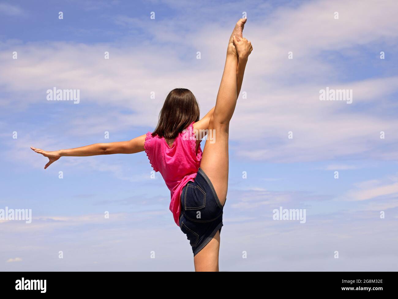caucasian girl performing rhythmic gymnastics exercises with the leg up ...