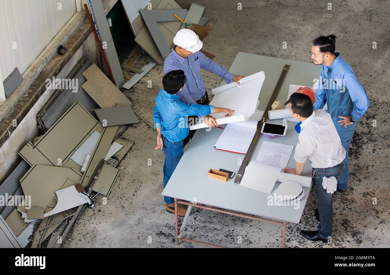 Group of four people including engineer and businessmen discuss and ...