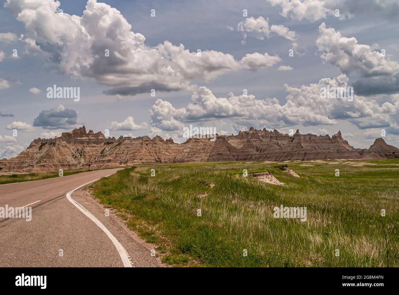 Badlands National Park, SD, USA - June 1, 2008: Road on side of green ...