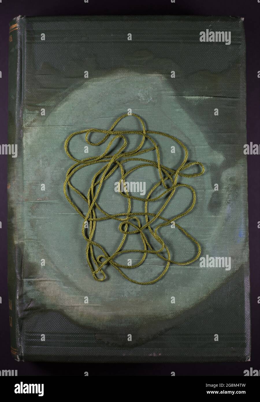 An old weathered and water damaged book with a "scribble" of string on ...