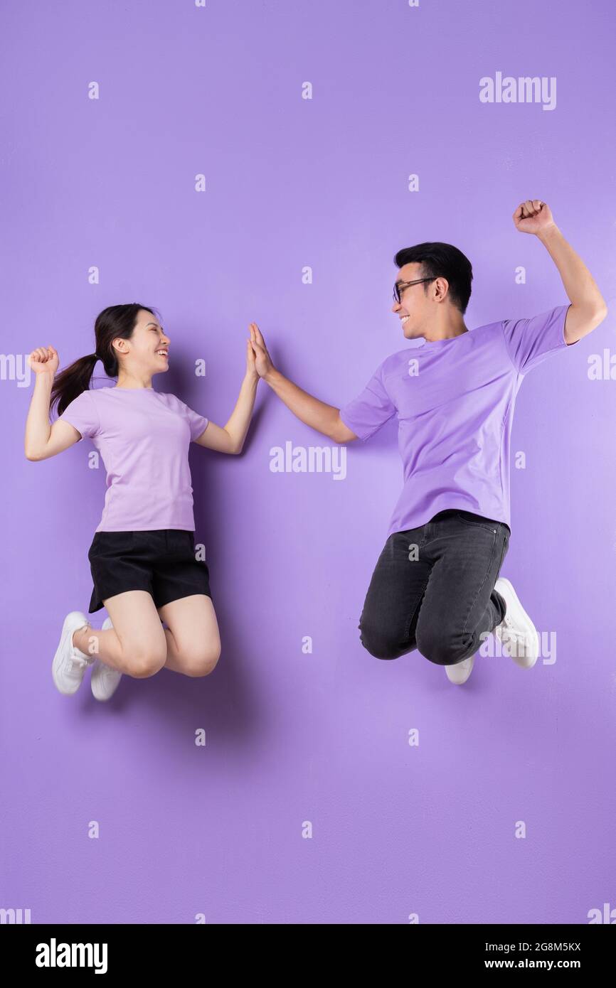 Young Vietnamese students happily jumping and giving high five on ...