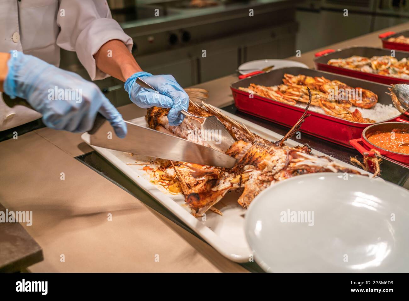 Chef cutting Grilled fish in the buffet restaurant Stock Photo - Alamy