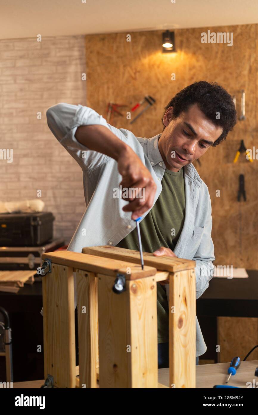 Carpenter finishing the screw with a screwdriver in his hand, the final ...