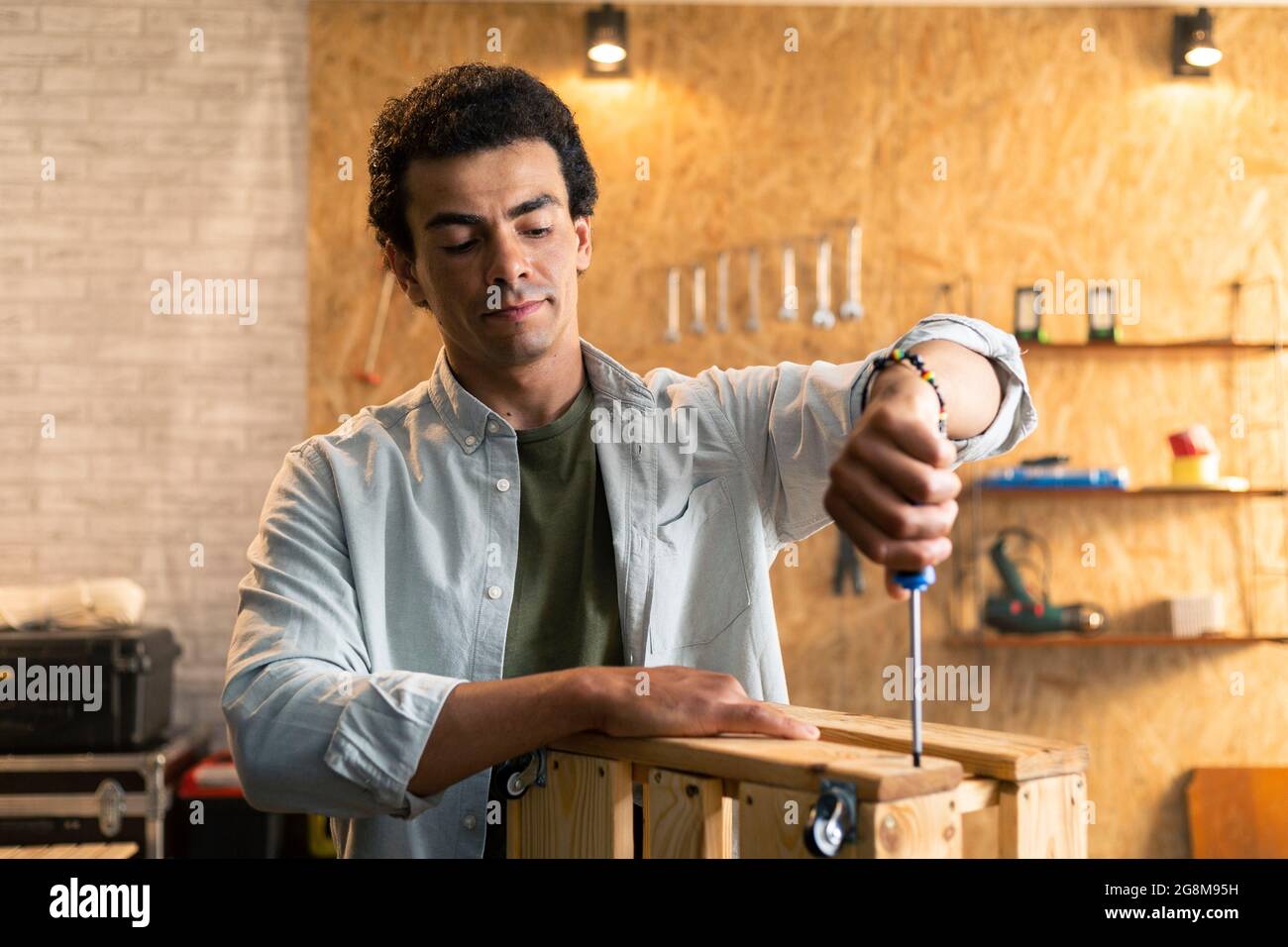 Carpenter finishing the screw with a screwdriver in his hand, the final ...