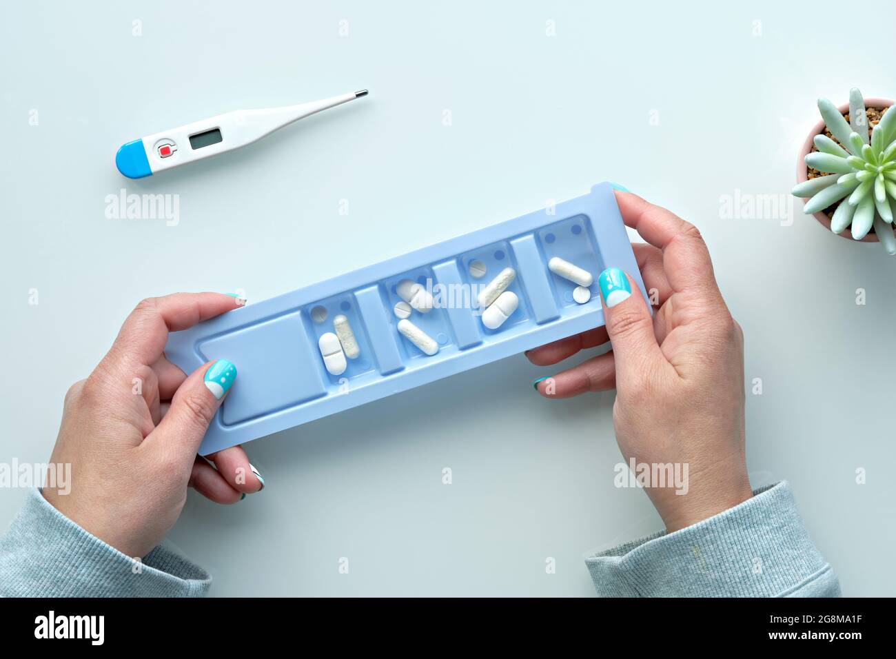 Patient hands hold plastic container with pills. Plastic container with ...
