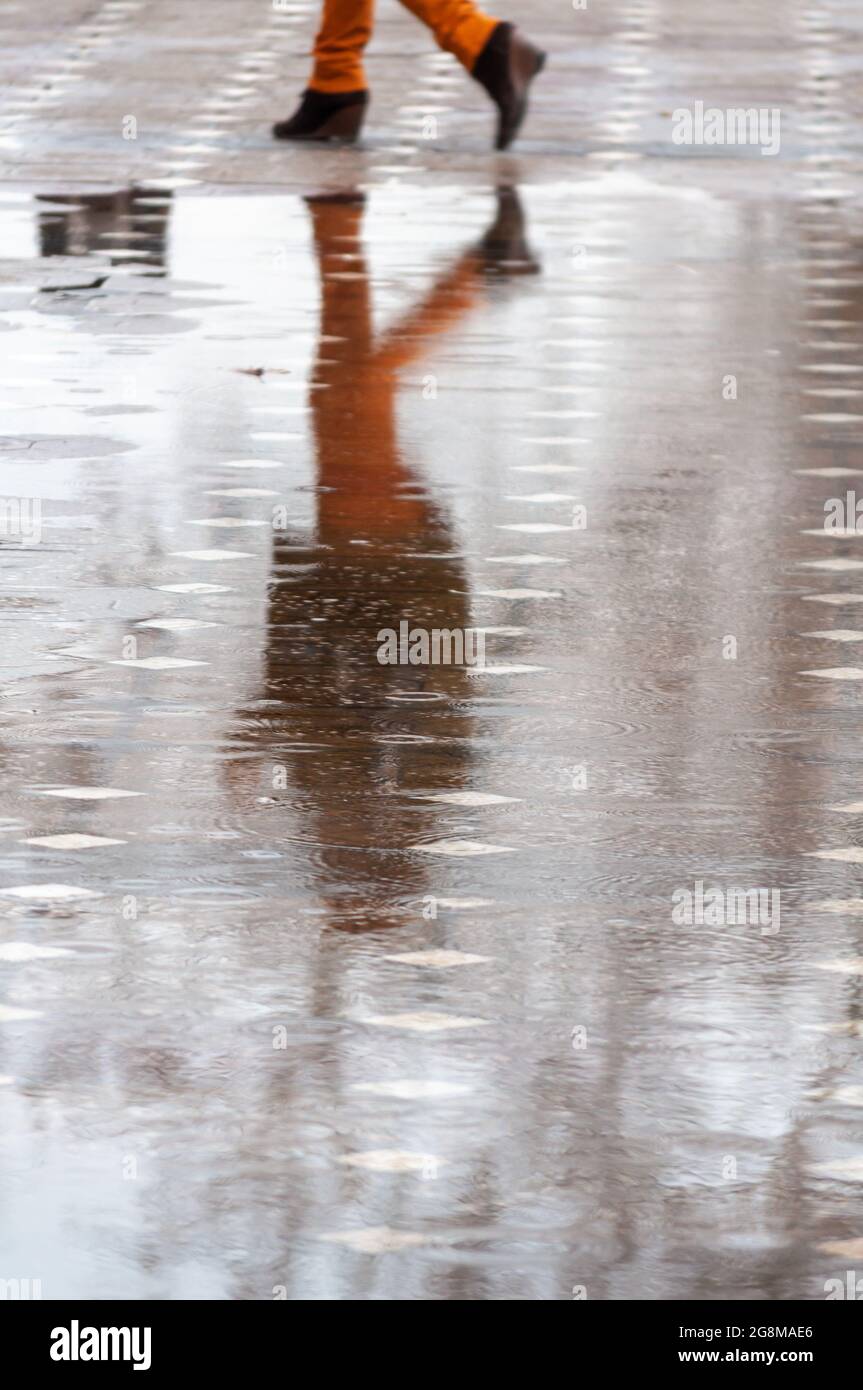 People walking on the street. Reflection in water. Real people Stock ...