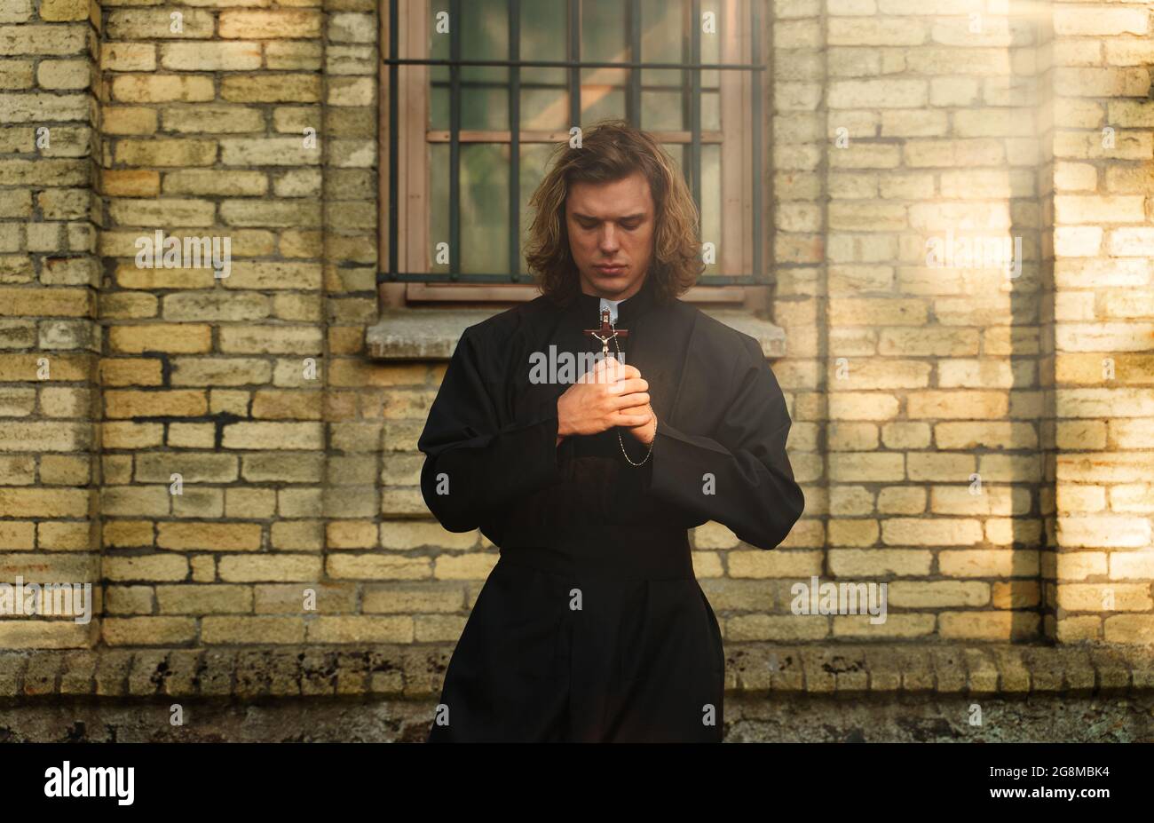 Christian priest with cross praying by the church Stock Photo - Alamy