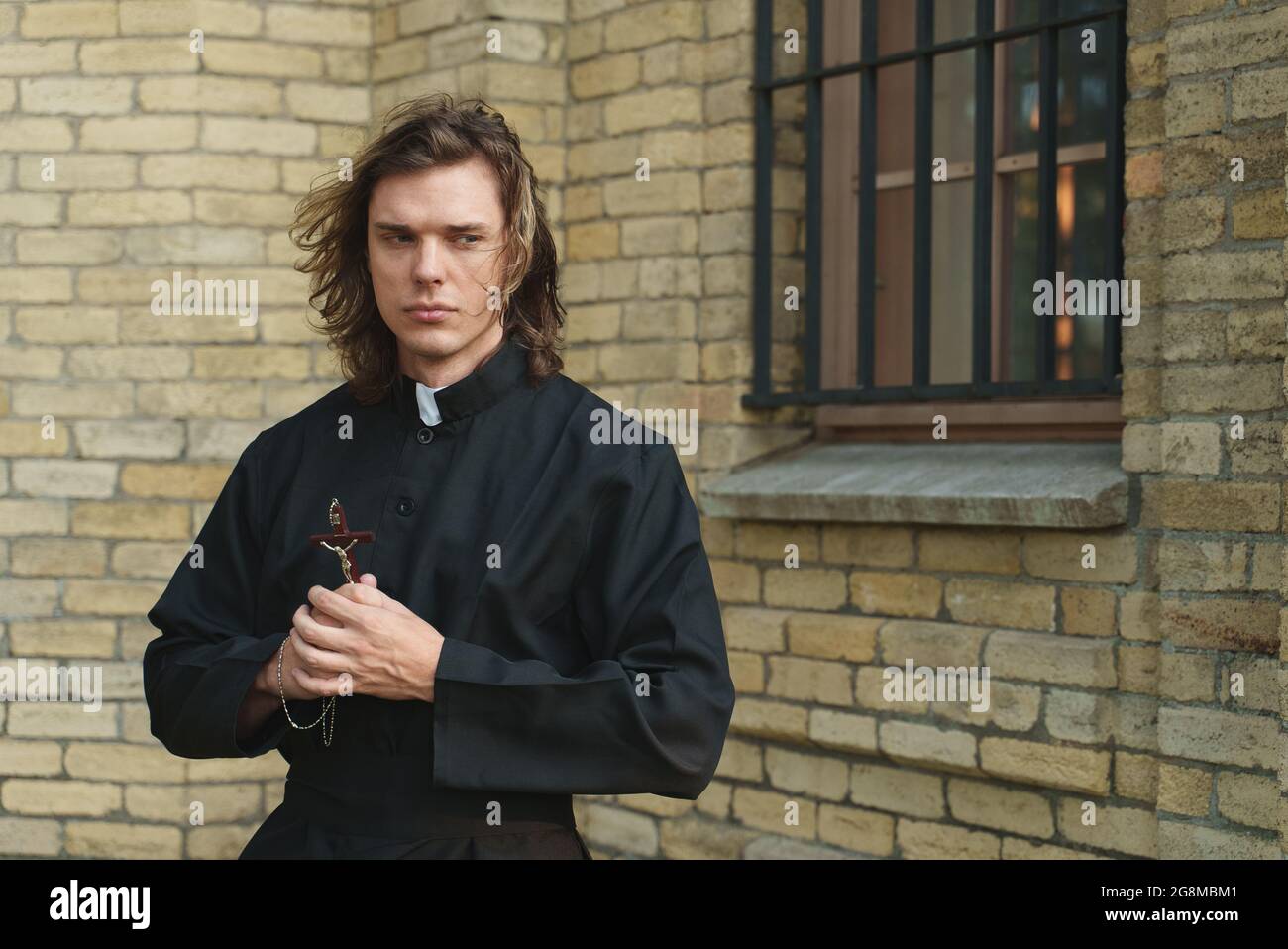 Christian priest with cross standing by the church Stock Photo - Alamy