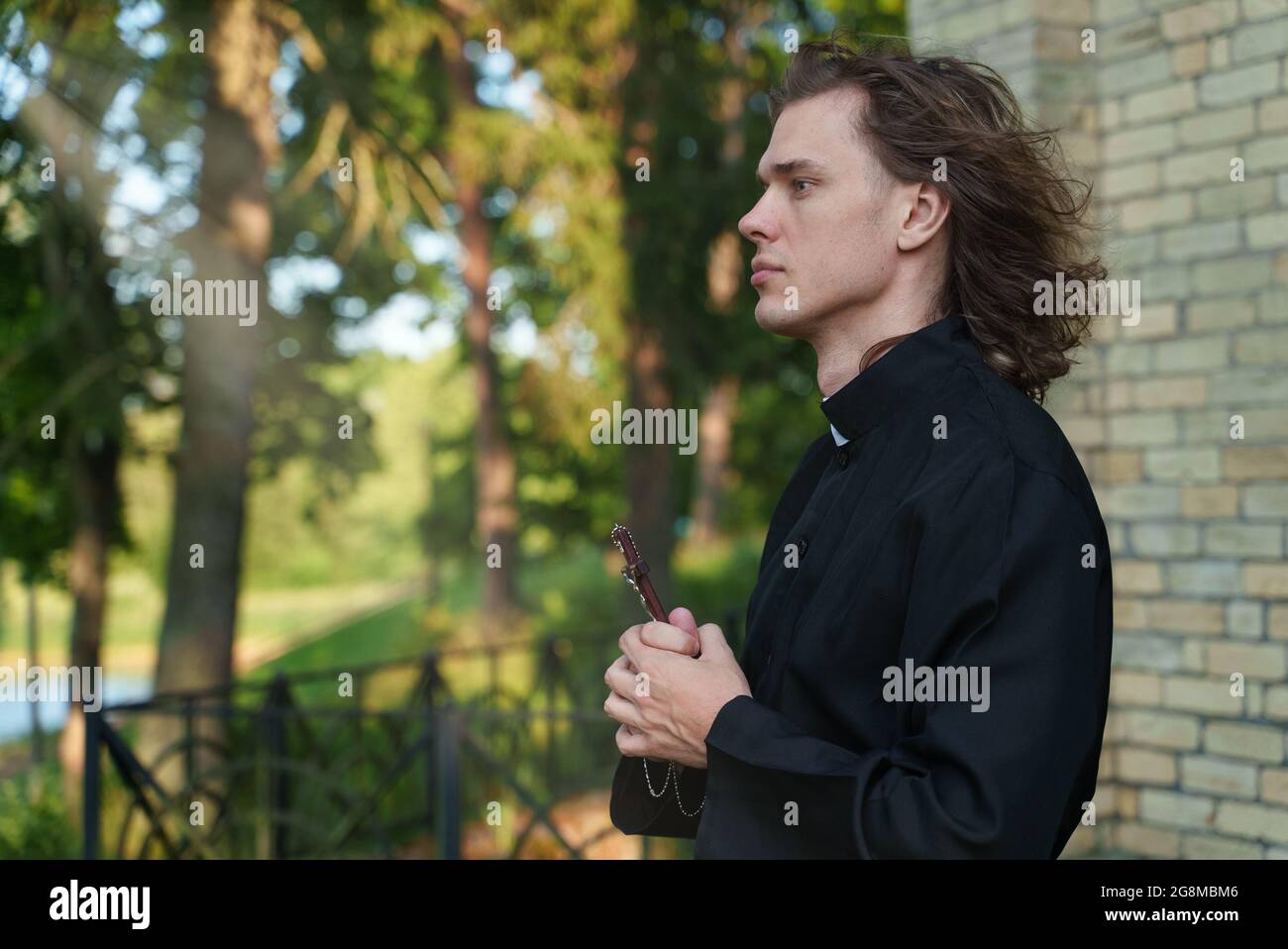 Christian priest with cross standing by the church Stock Photo - Alamy
