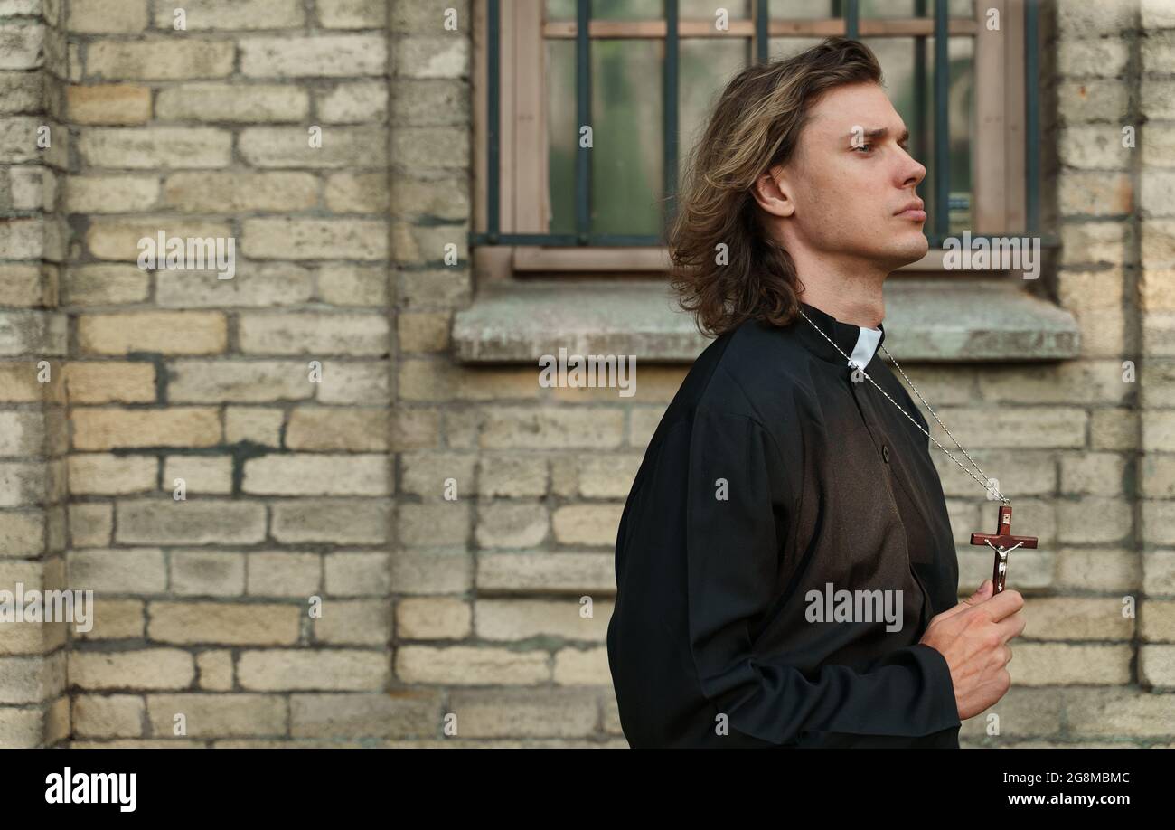 Christian priest with cross standing by the church Stock Photo - Alamy
