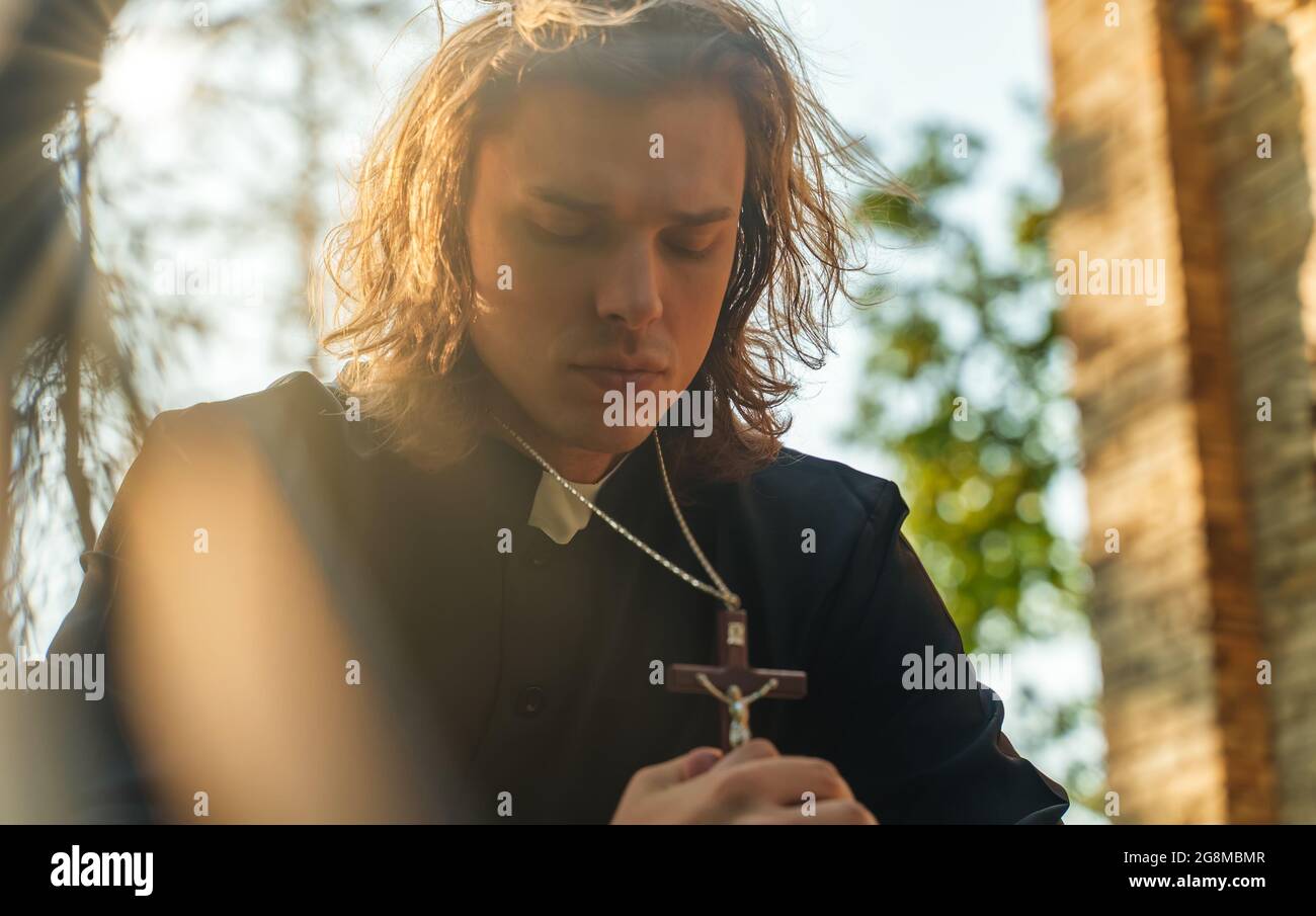 Christian priest with cross praying by the church Stock Photo - Alamy
