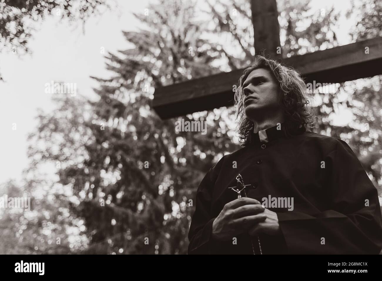 Christian priest with cross on the cemetery Stock Photo - Alamy