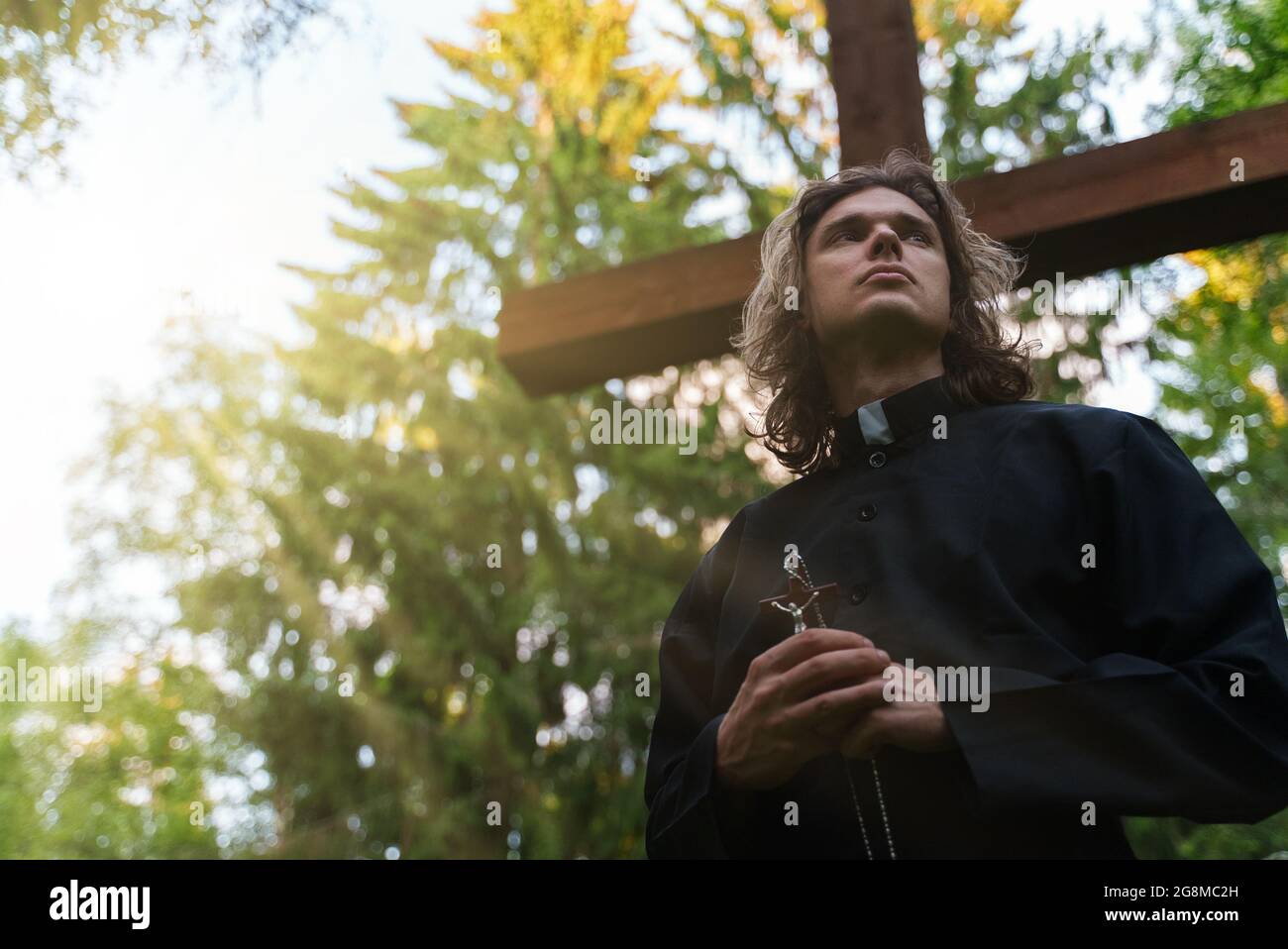 Christian priest with cross on the cemetery Stock Photo - Alamy