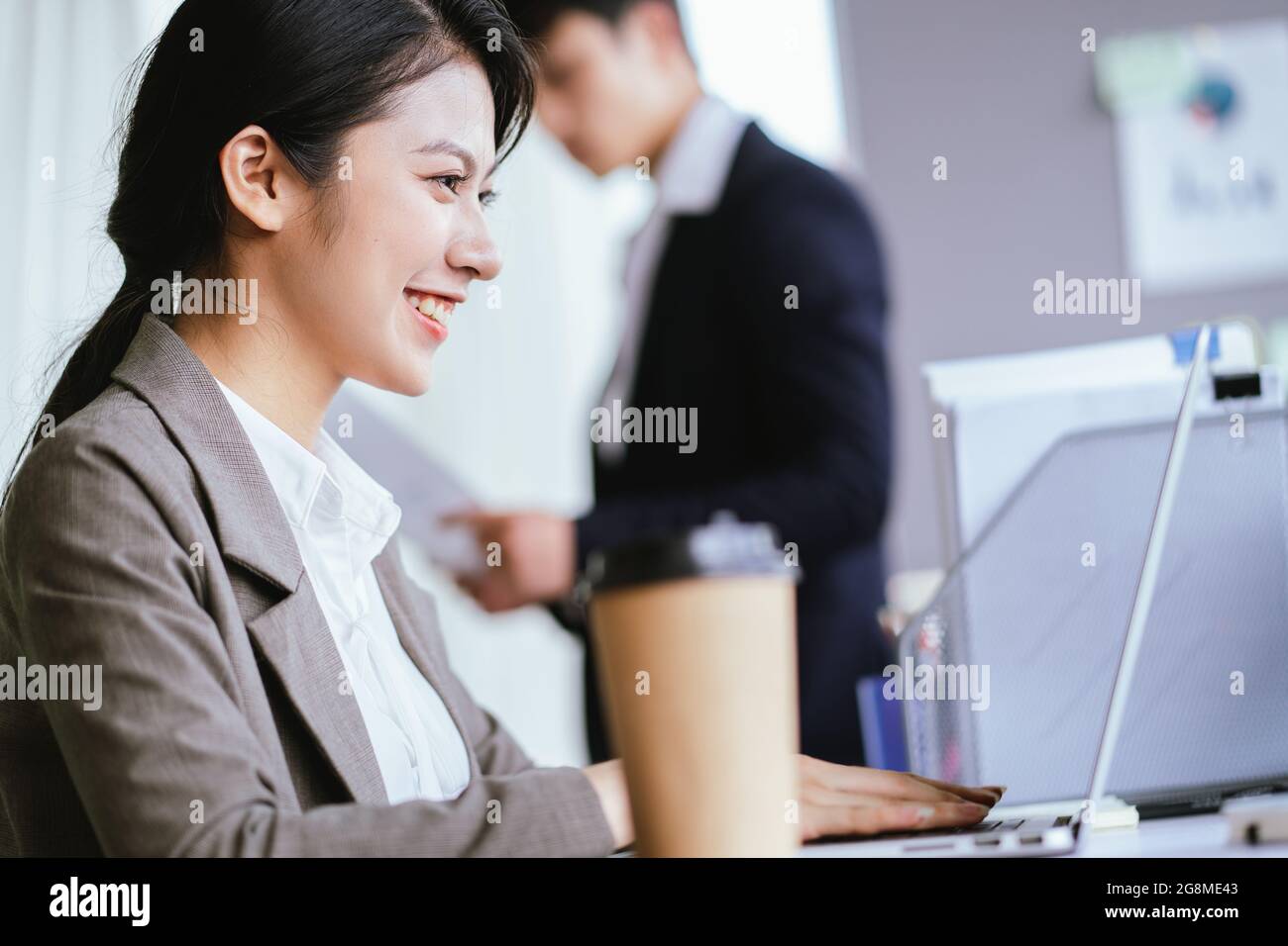 Selective focus of a young Vietnamese female employee happily working ...