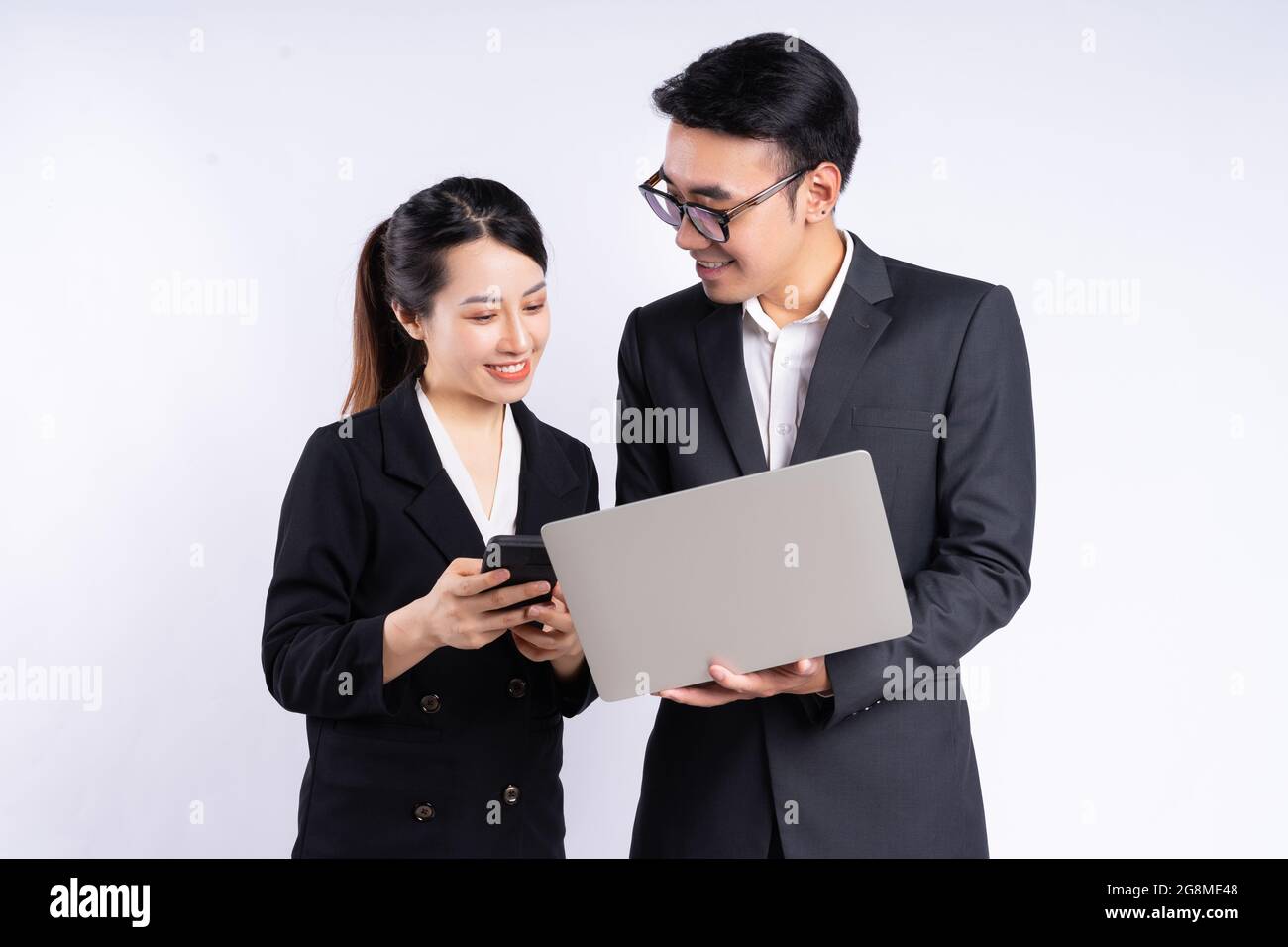 Young Vietnamese employees in suits working on the laptop on background ...