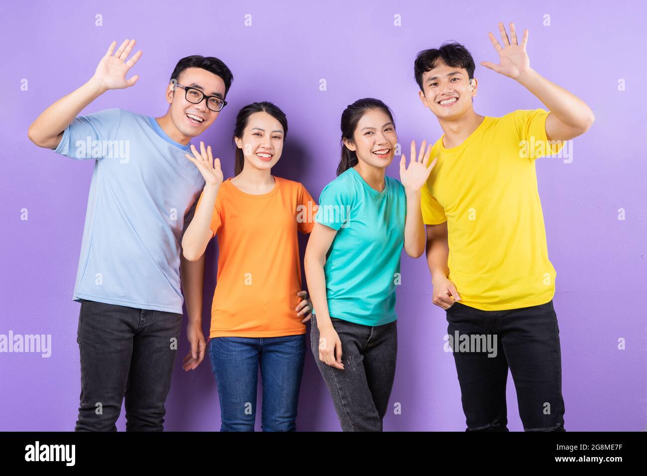 Group of young Vietnamese friends in colorful shirts waving at the ...