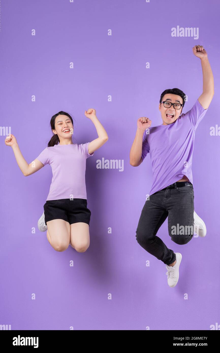 Young Vietnamese students happily jumping with raised fists on vibrant ...