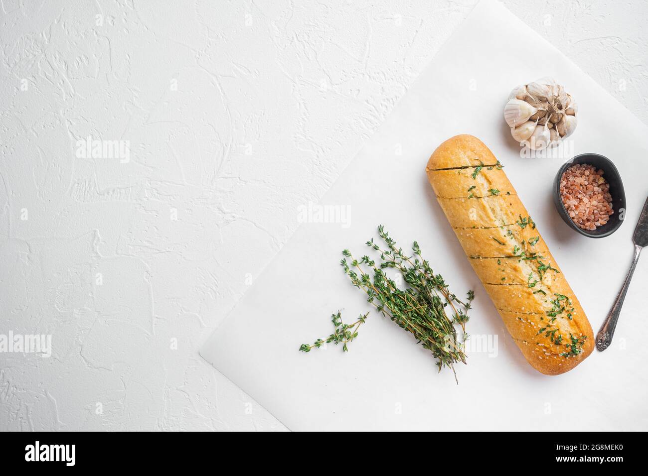 Toasted bread with garlic and herbs set, on white stone table ...