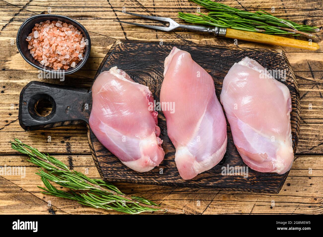 Boneless Raw Chicken thigh fillet. Wooden background. Top view Stock ...