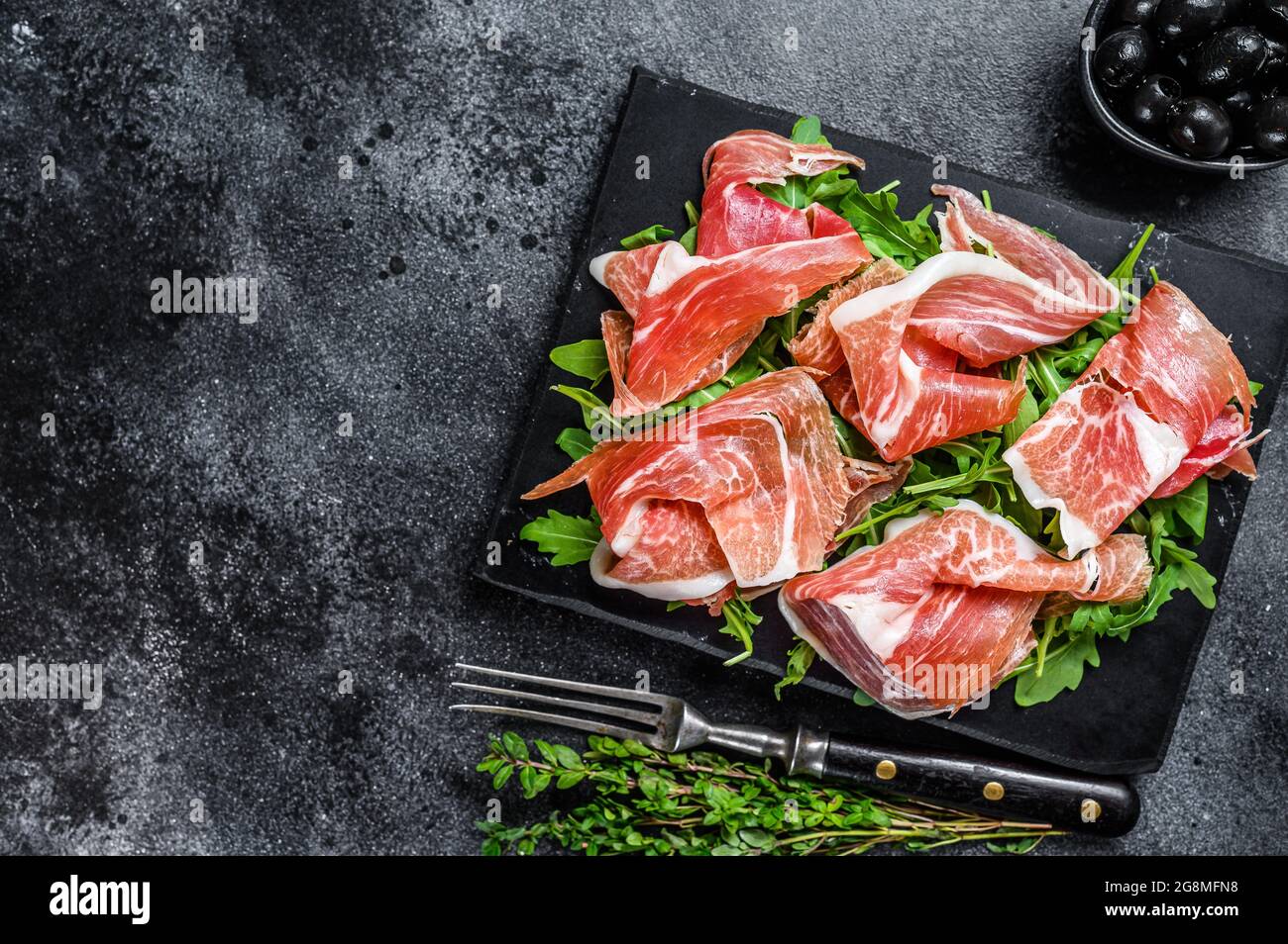 Sliced Jamon serrano pork ham meat on a marble board. Black background ...