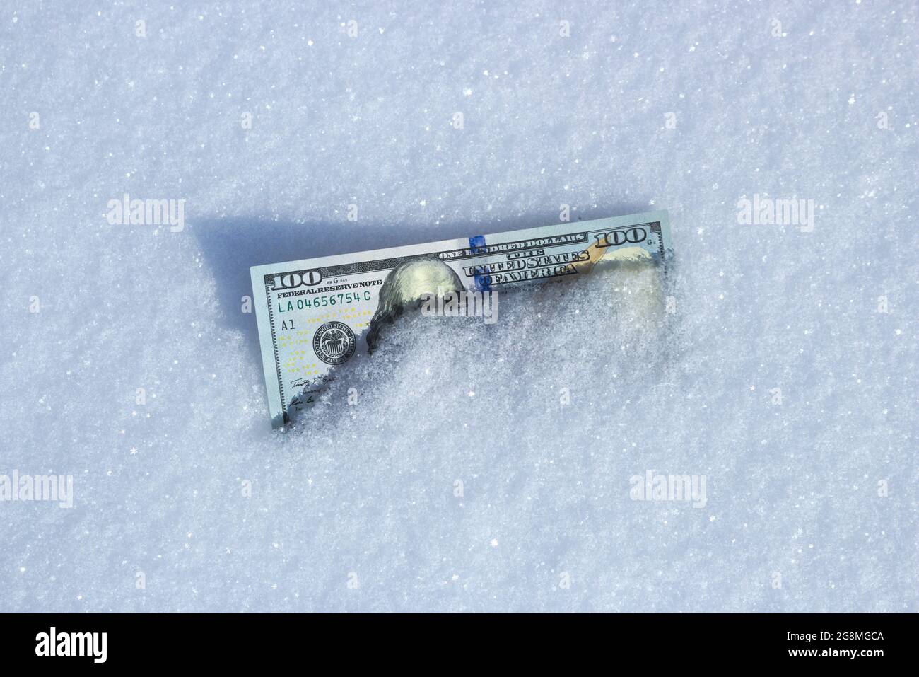 American currency lies in the snow. Frozen money concept Stock Photo ...