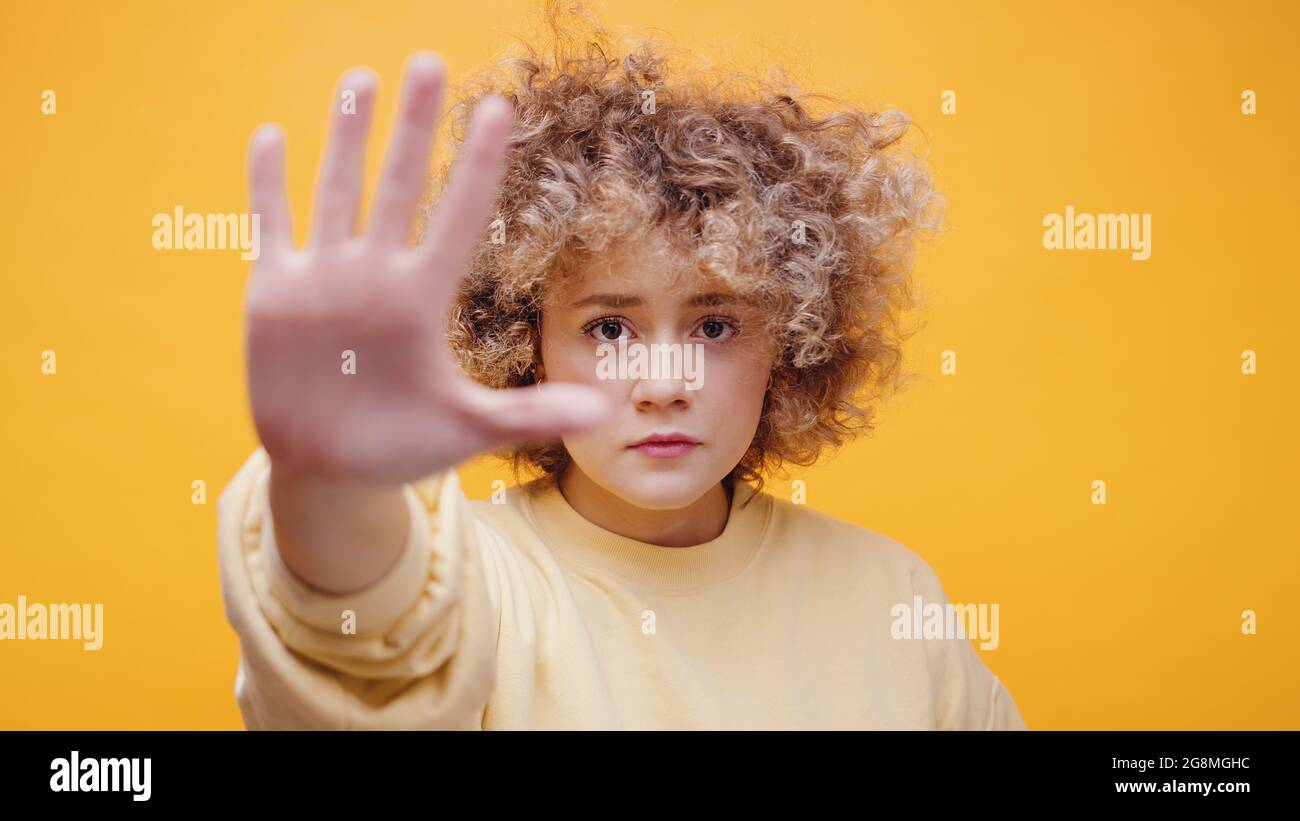 Girl making stop hand gesture. Serious young girl making a stop sign ...
