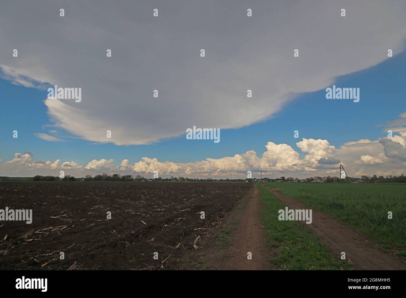 Huge cloud over an empty countryside road and fields Stock Photo - Alamy