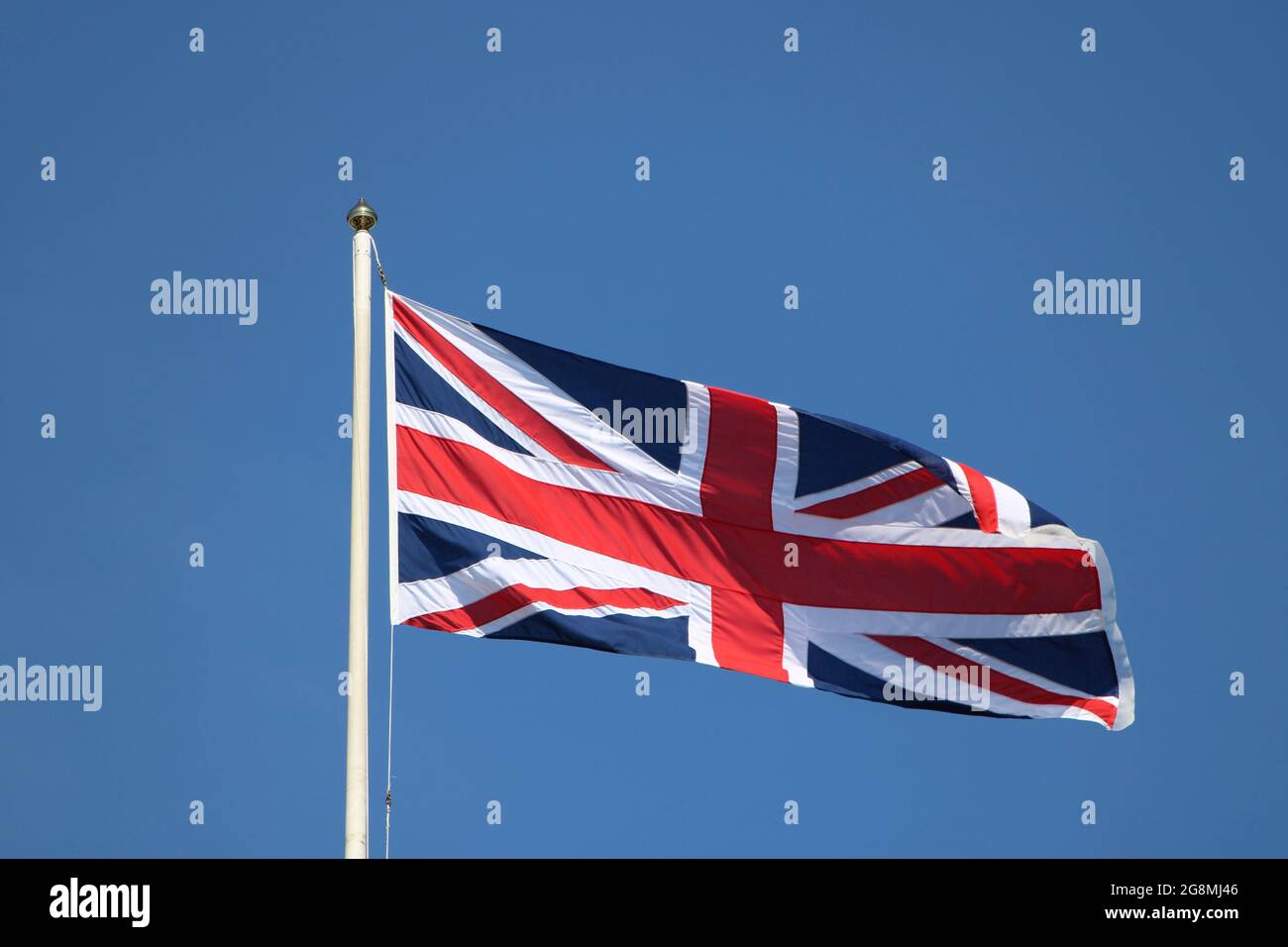 Union Jack Flag Flying in a Flagpole on Blue Sky Background Stock Photo ...