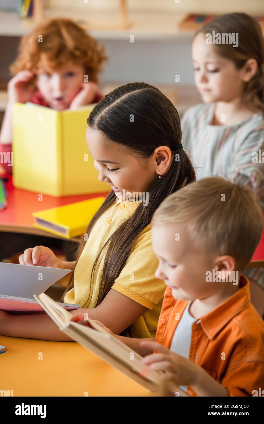 multiethnic kids reading books in classroom on blurred background Stock ...