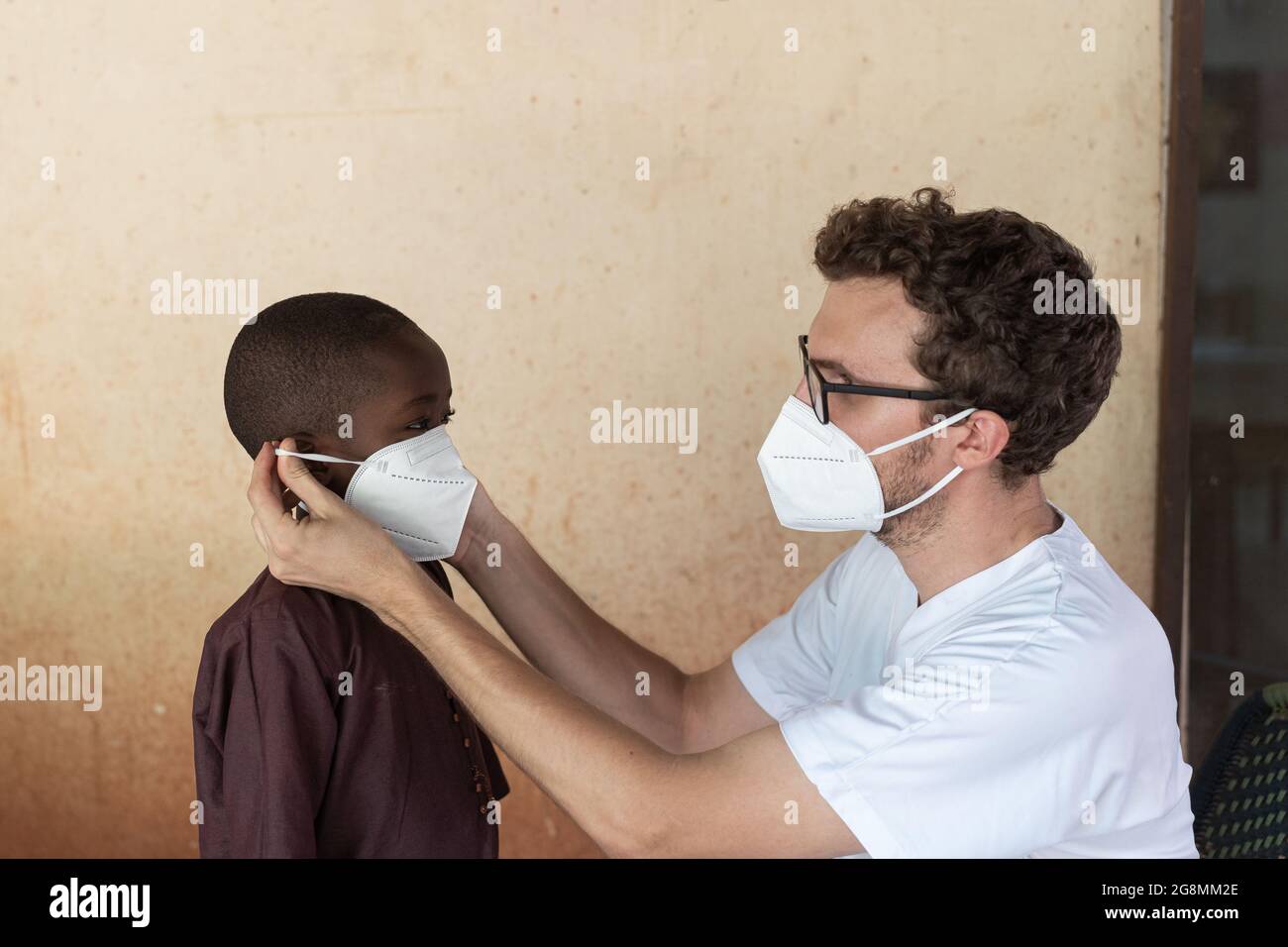 Picture of a caucasian volunteering doctor helping black African boy ...