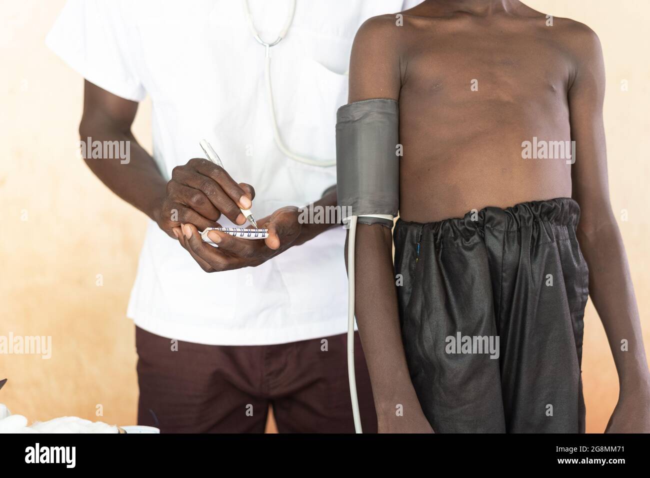 This is an image of an African ethnicity doctor or nurse measuring ...