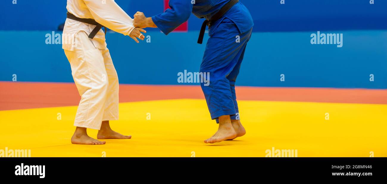 Two judo fighters in white and blue uniform. Horizontal sport poster ...
