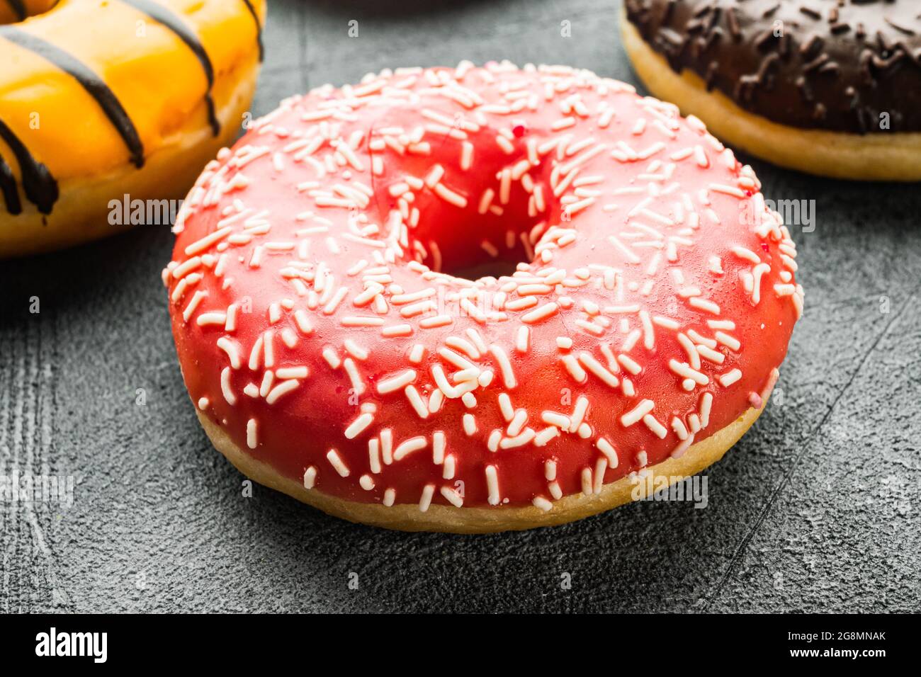 Pink strawberry flavor donuts, on gray background Stock Photo - Alamy