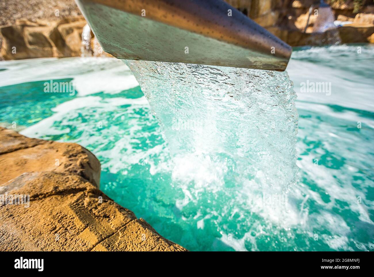 Stream water out of artificial waterfall in outdoor pool Stock Photo ...