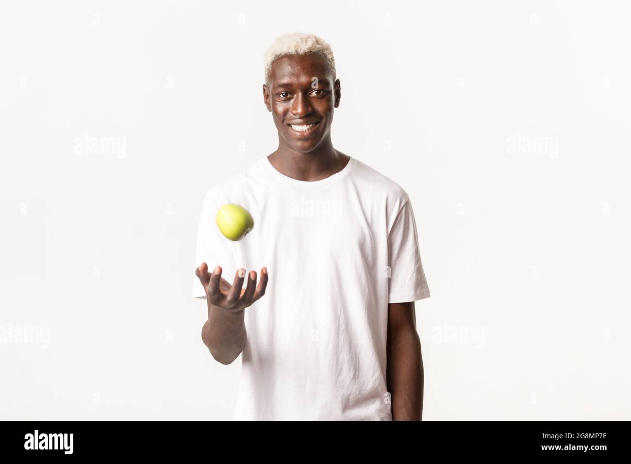 Portrait of sassy handsome african-american blond guy, catching apple ...