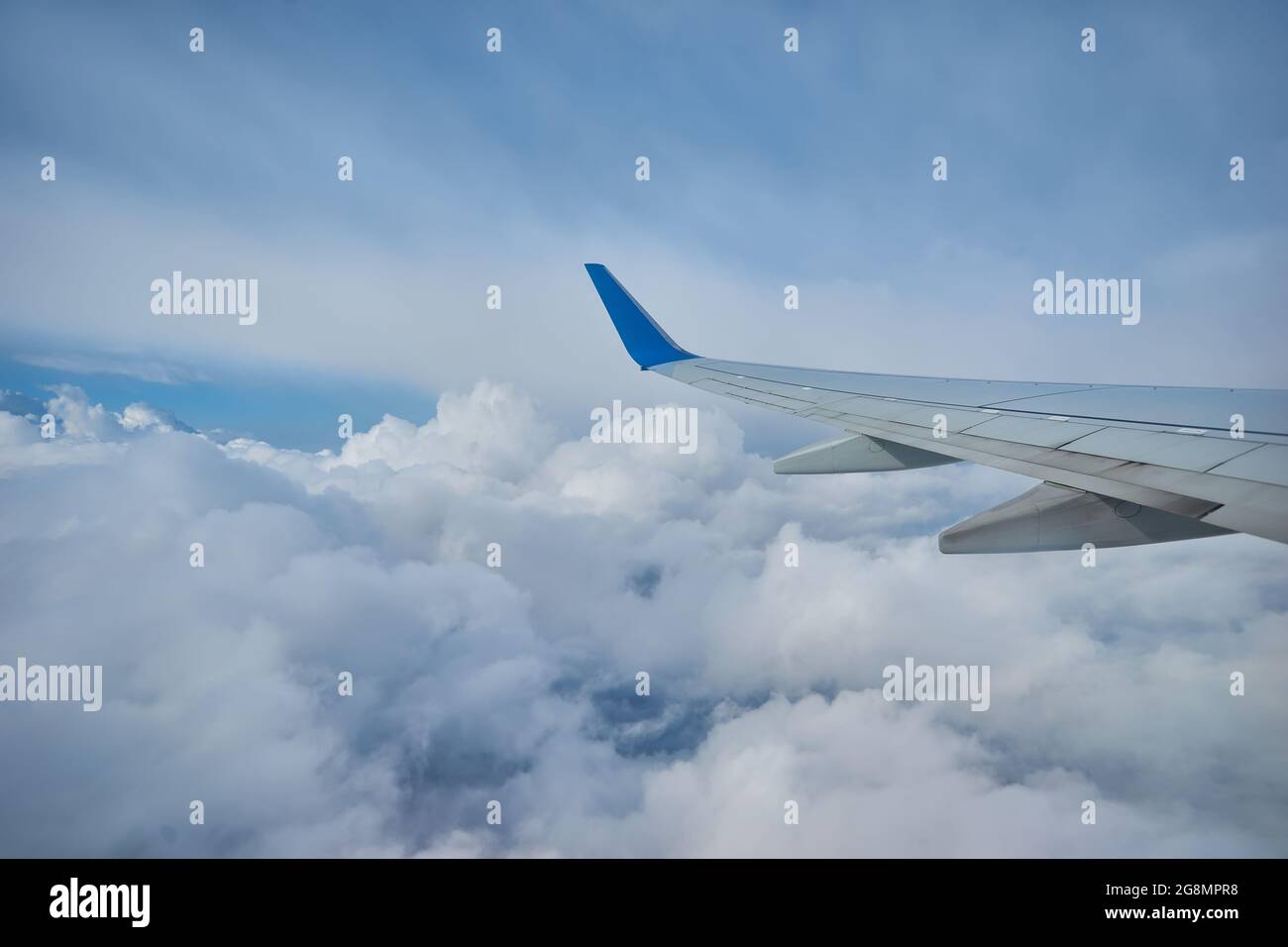 Wing of an airplane flying above the clouds. people looks at the sky ...