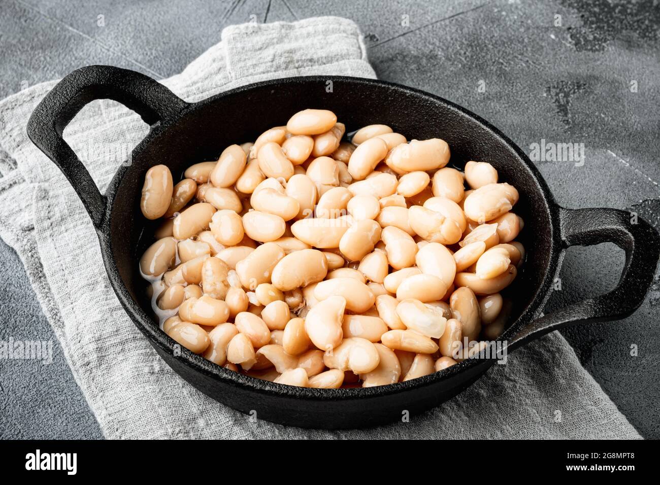 White canned beans set, in cast iron frying pan, on gray stone ...